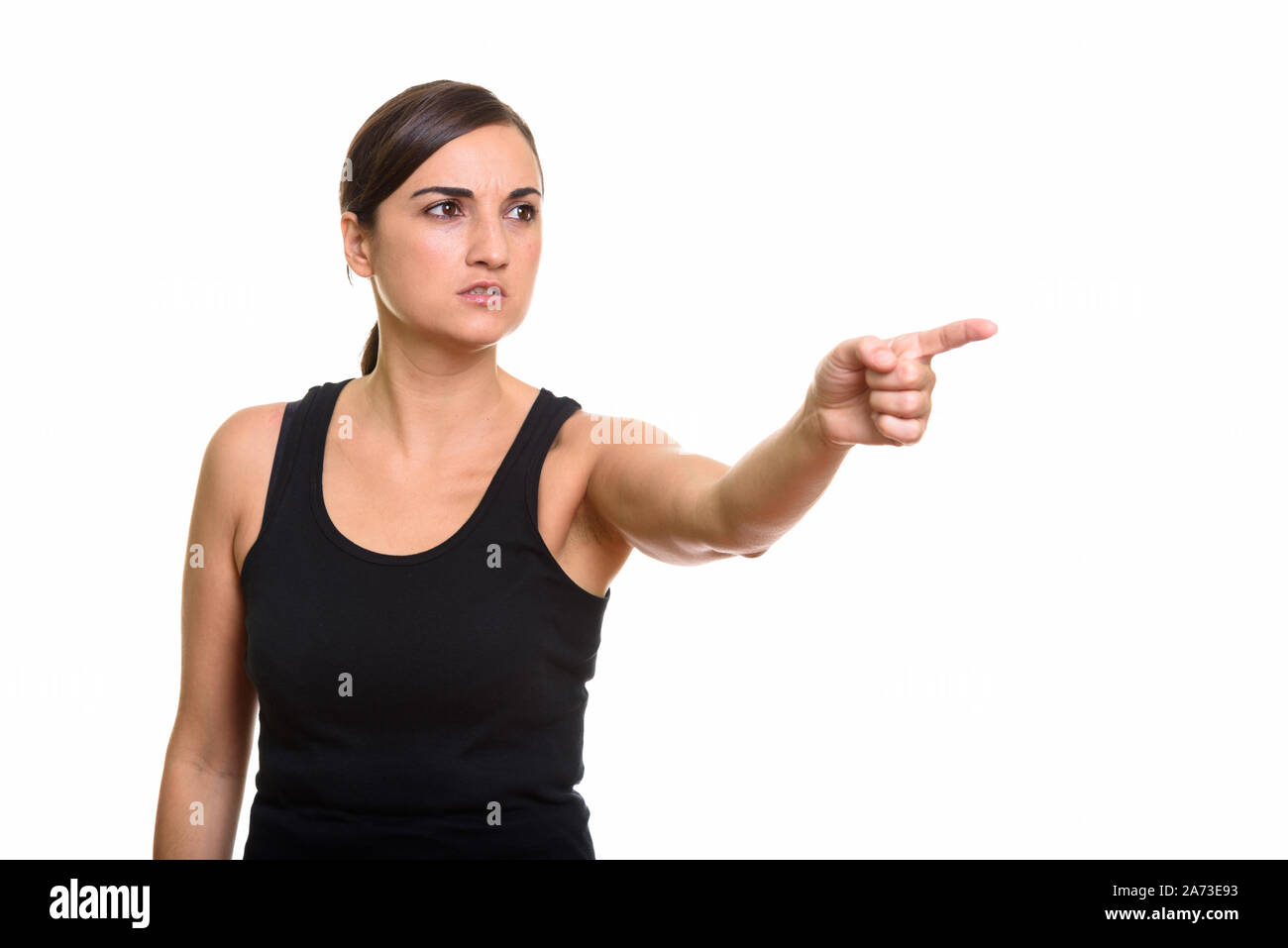 Studio shot of beautiful woman looking angry while pointing finger ...