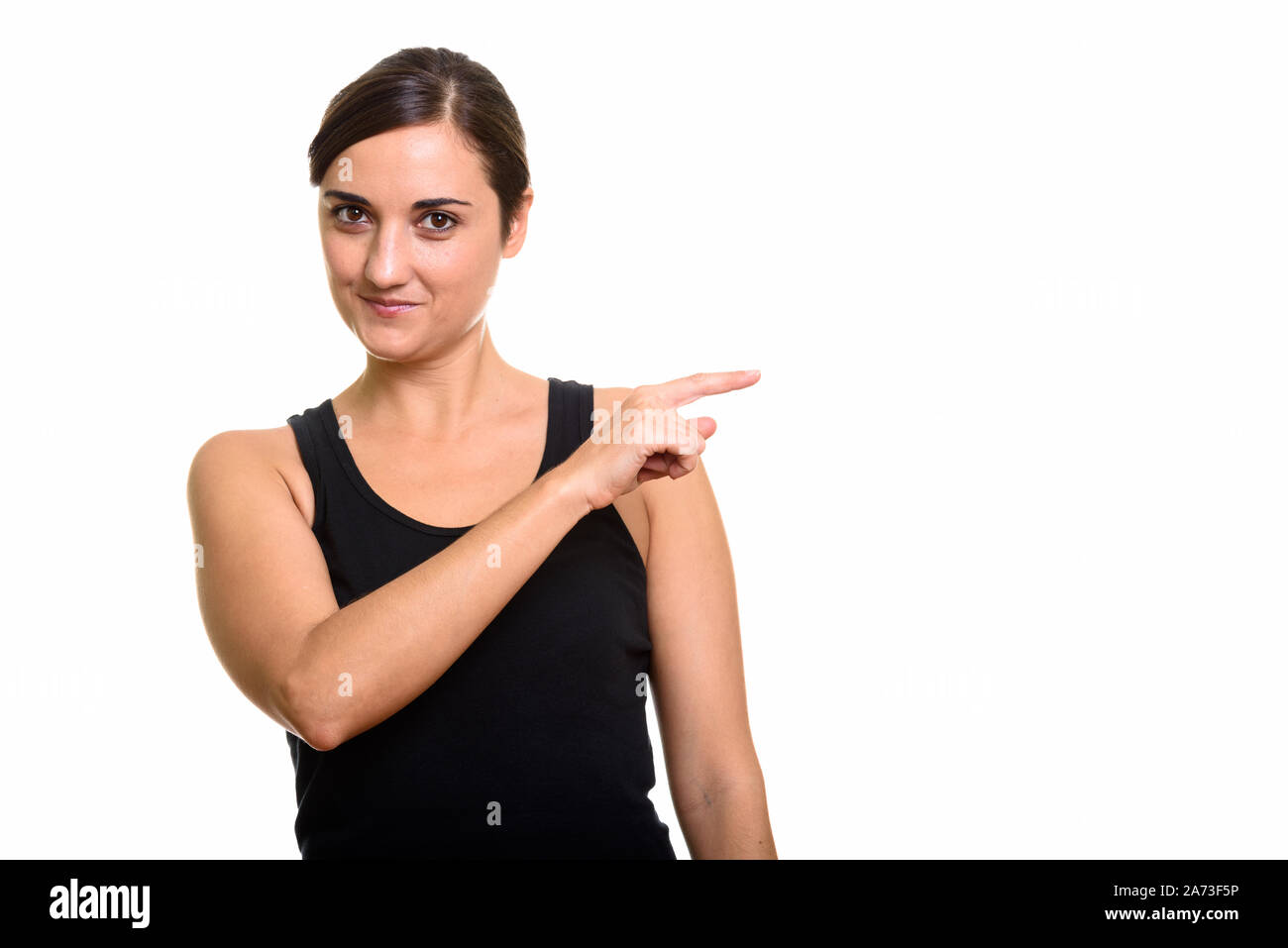 Studio shot of beautiful woman pointing finger at side Stock Photo - Alamy