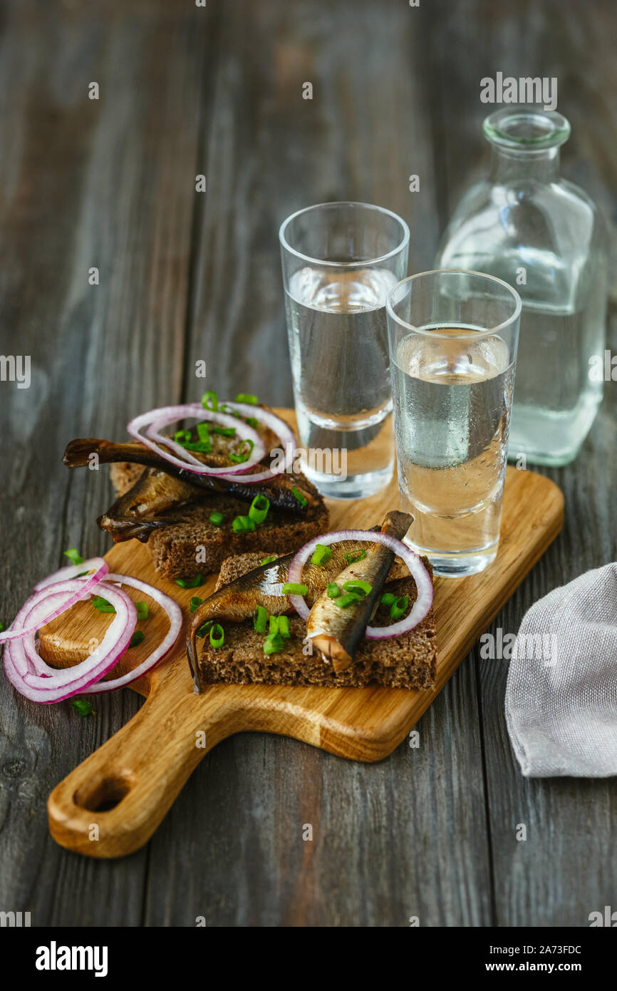 Vodka with fish and bread toast on wooden background. Alcohol pure ...