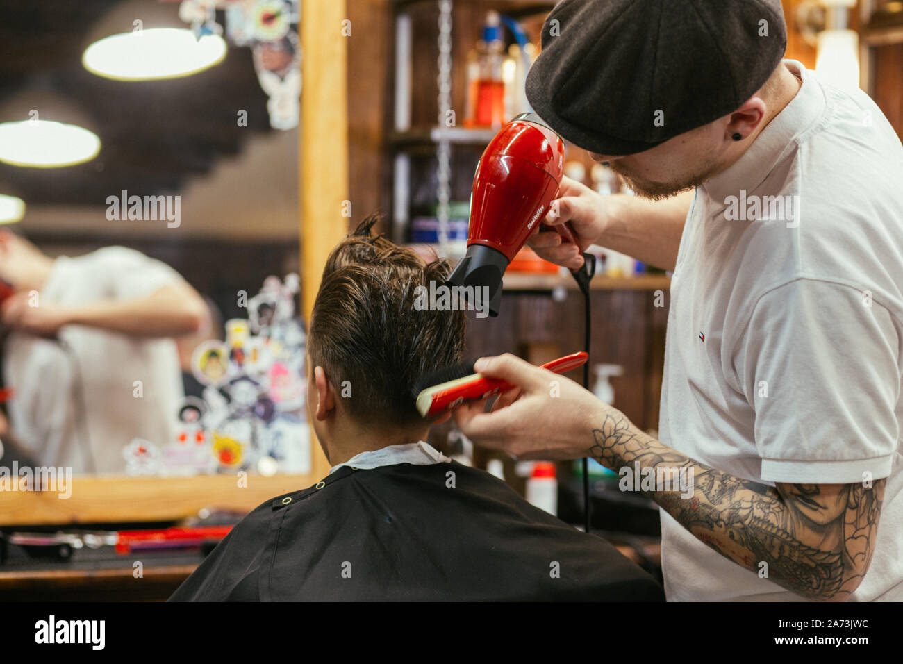 Teenage boy haircuts hairdresser in the Barber shop. Fashionable ...