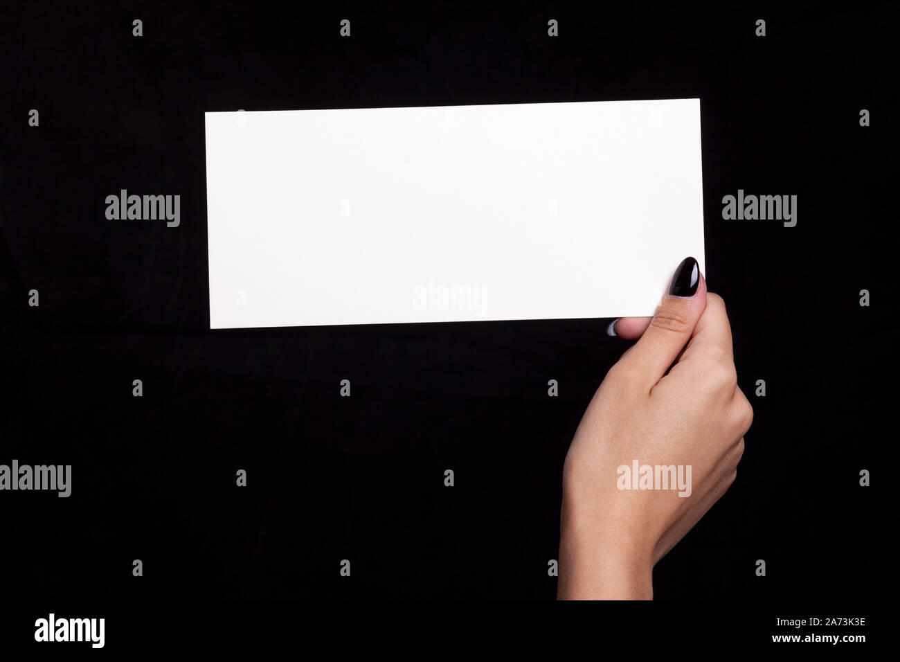 hand holding white card on black background - copyspace Stock Photo - Alamy