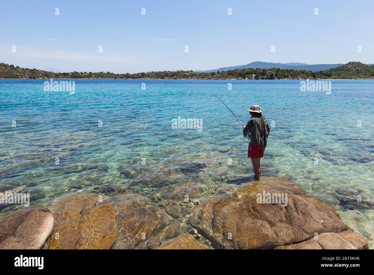Unrecognizable man fishing in the sea bay at summer day . Beautiful ...