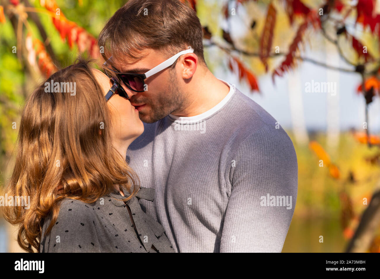 Romantic young coupe kissing in the garden in autumn against a ...