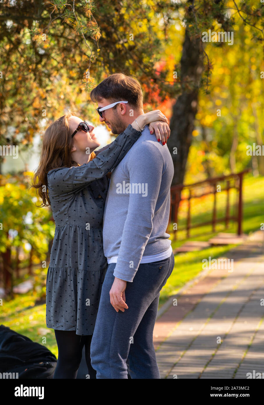 Loving couple hugging in an autumn park in a three-quarter portrait ...