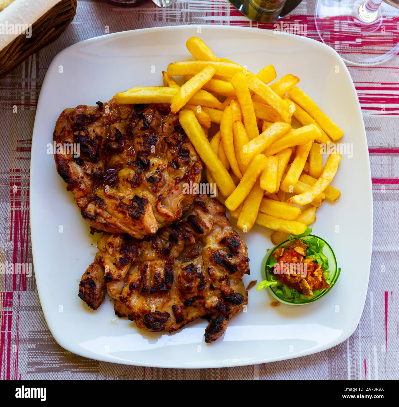 Grilled boneless chicken thighs (Pileci Batak) served with fries and ...