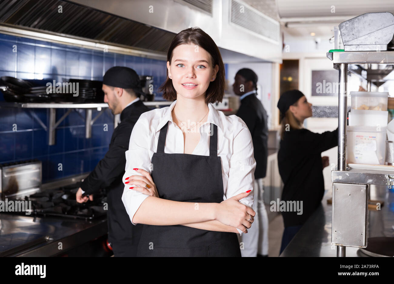 Portrait of woman waiter is posing stand on kitchen in restaurant Stock ...