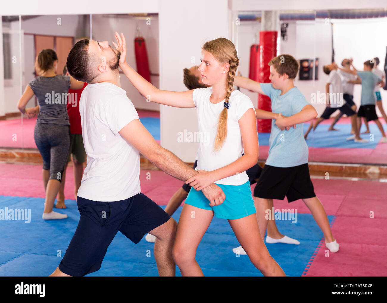 Kids with adults practicing effective techniques of self-defence in ...