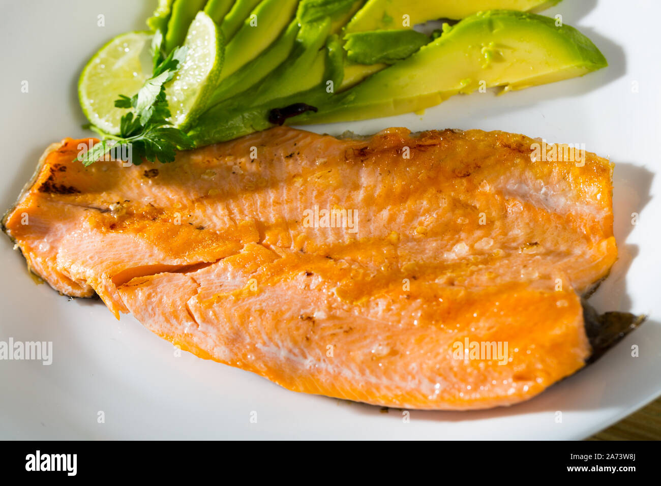 Photography of plate with fried trout fillet with avocado in ...