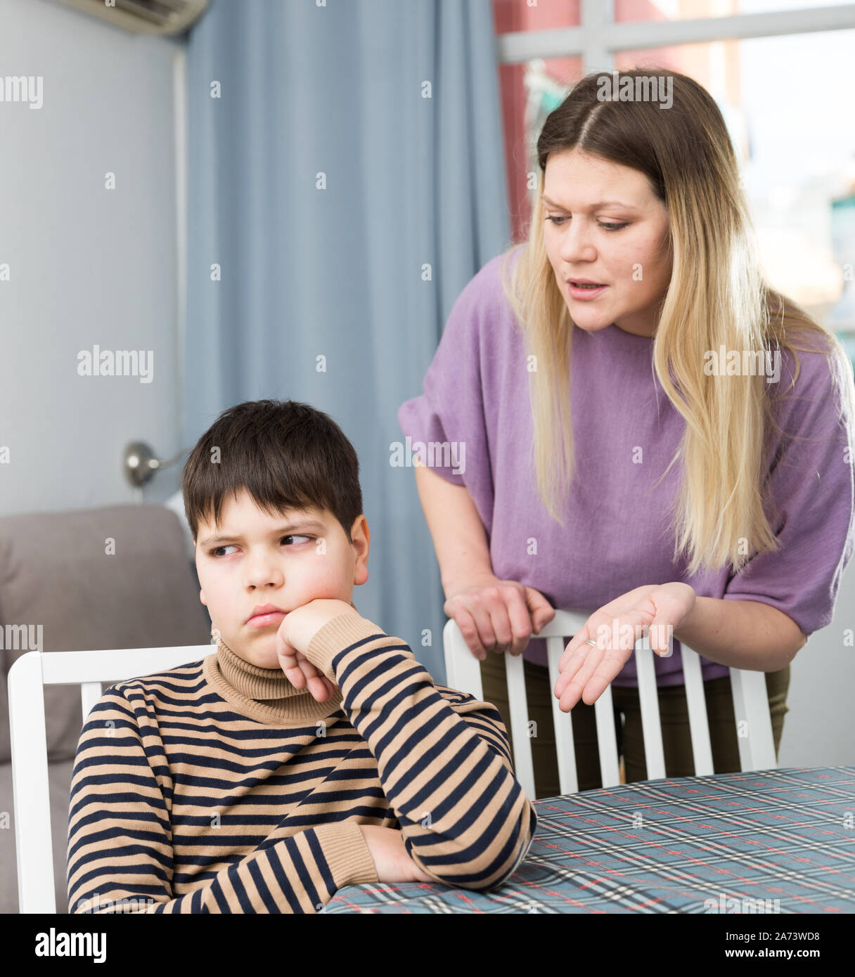 Upset mother and offended son arguing in domestic interior Stock Photo ...