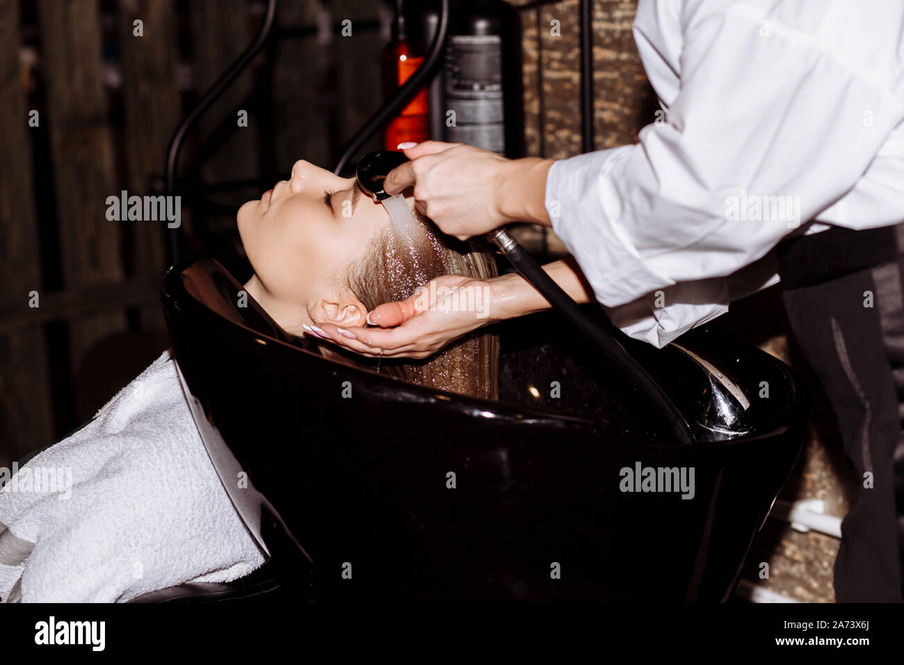 Gorgeous cute young woman enjoying head massage while professional ...