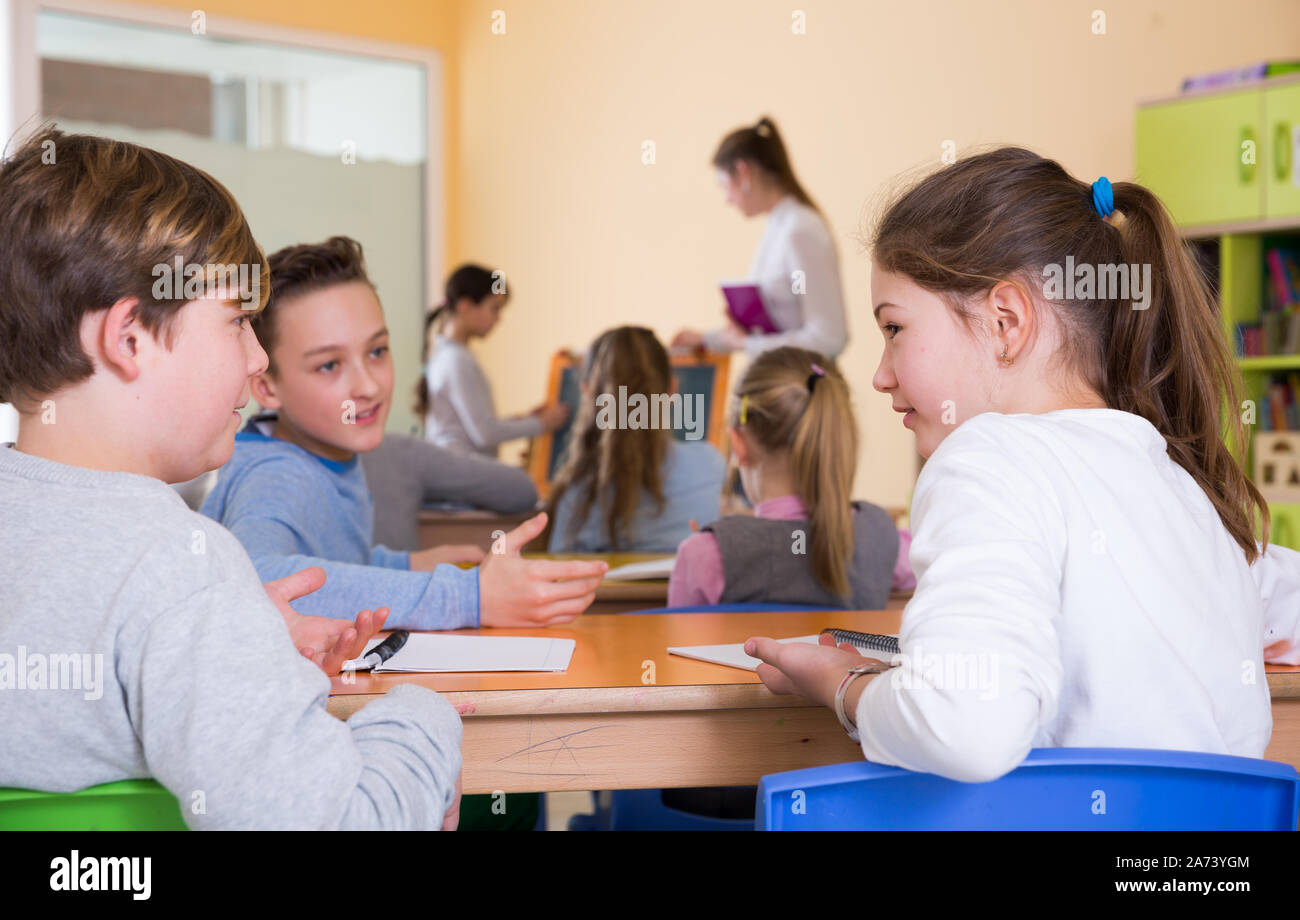 Happy students sitting desks hi-res stock photography and images - Alamy