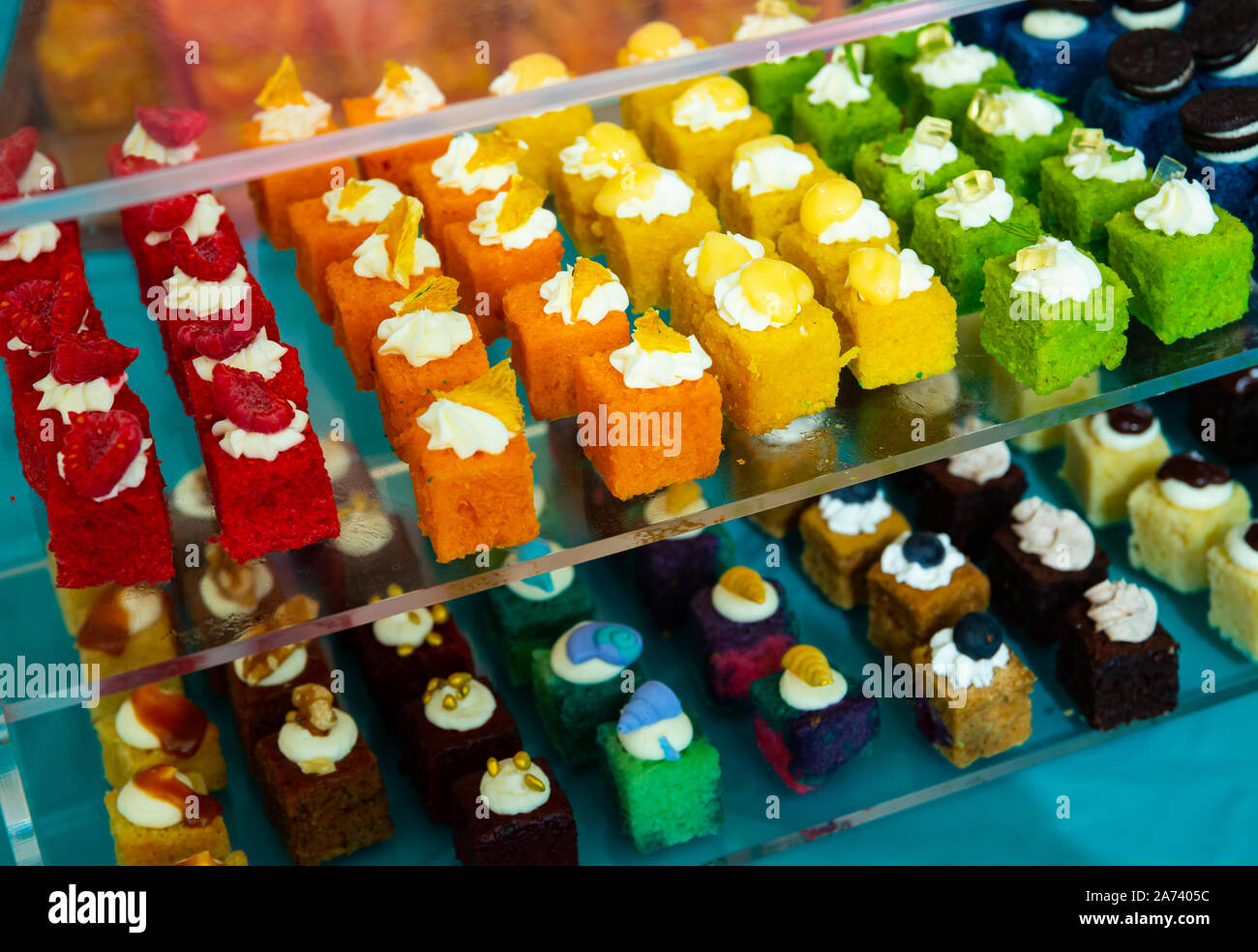 View of glass display with various colored biscuits in pastry shop in ...
