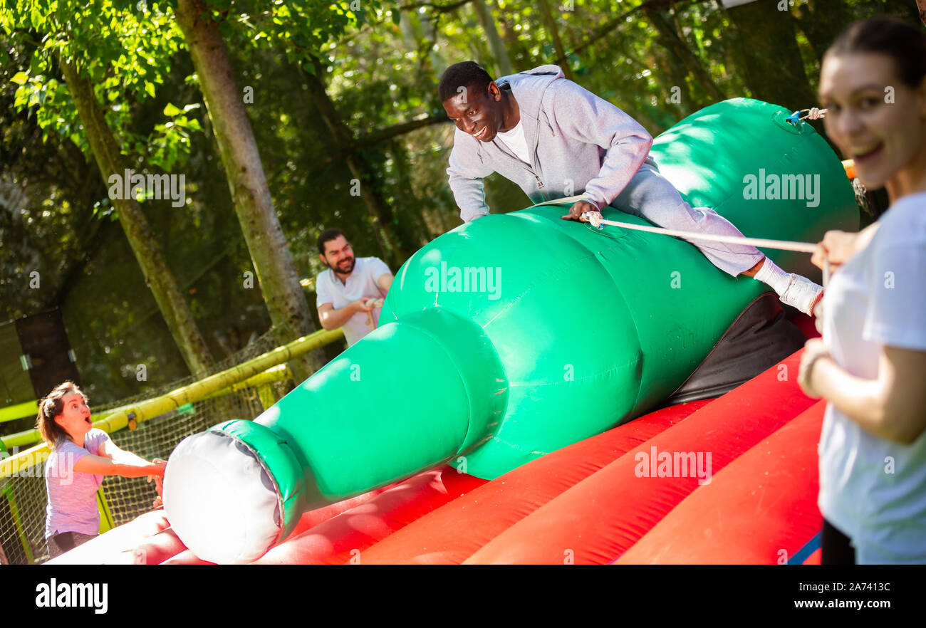 Attraction with a huge inflatable bottle - african-american man trying ...