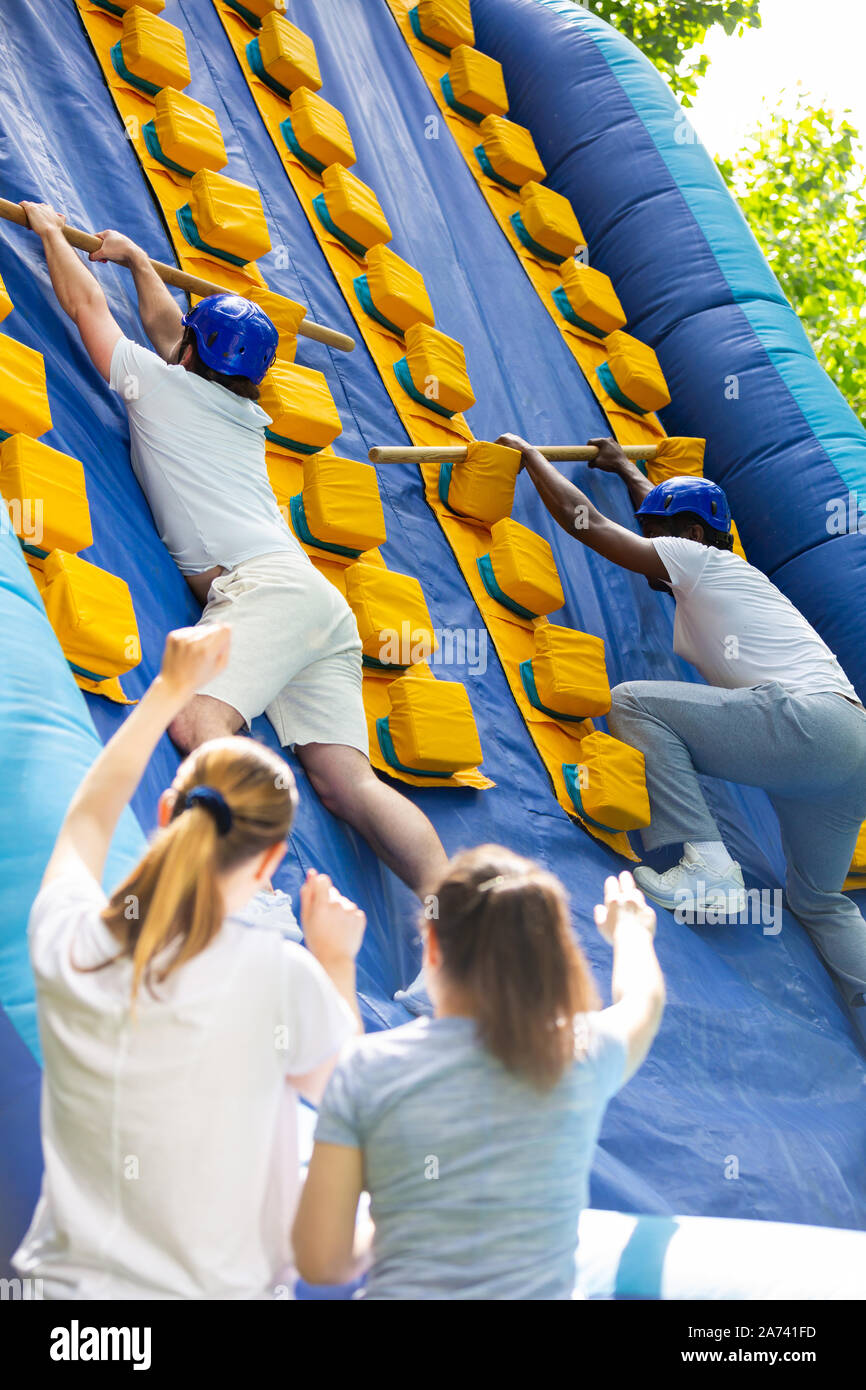 Mens competition on an inflatable slide Great race in an amusement park ...