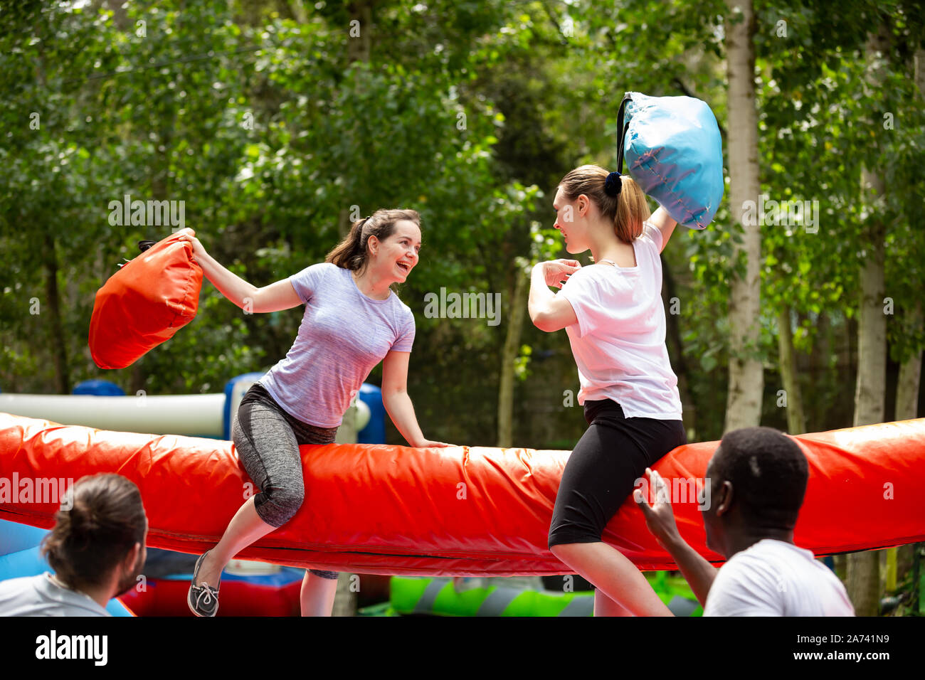 Cheerful adult women having fun on inflatable pillow fight arena in ...