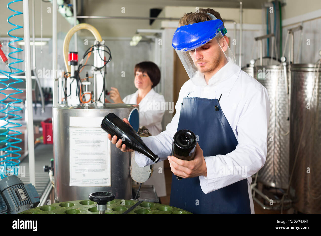 Young man worker winemaking at sparkling wine factory Stock Photo - Alamy