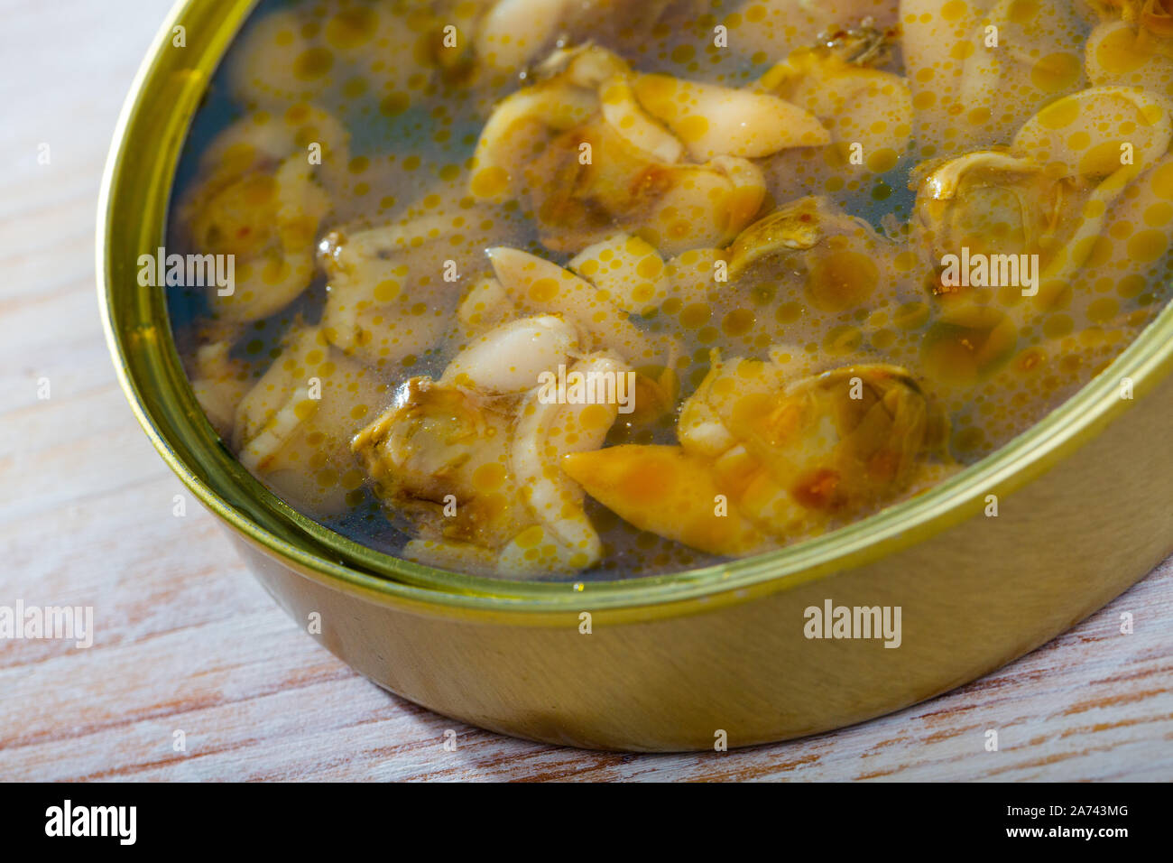 Marinated shellfish in an open tin can on wooden table Stock Photo - Alamy