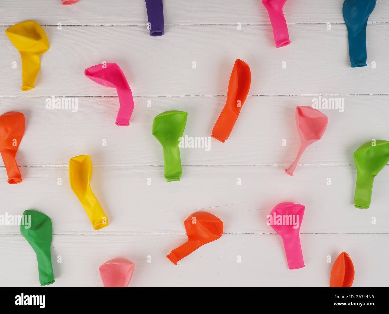 a lot of colorful balloons not inflated by air on a white background as ...