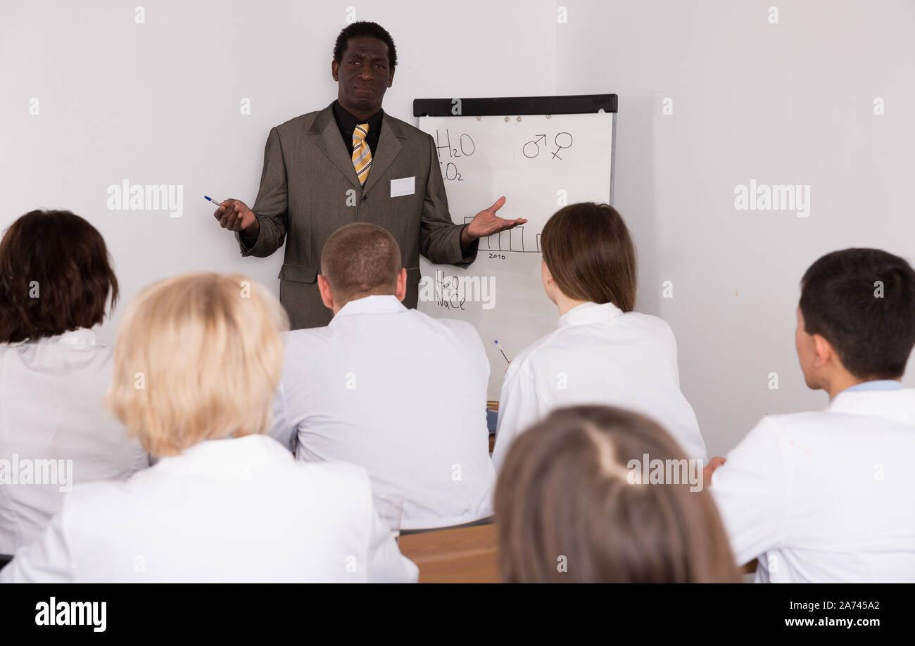 Confident African American male doctor lecturing to colleagues at ...