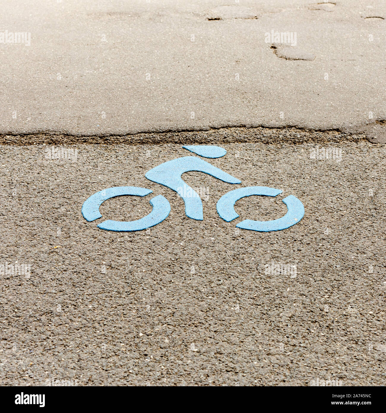 Blue bicycle lane sign depicted on asphalt Stock Photo - Alamy