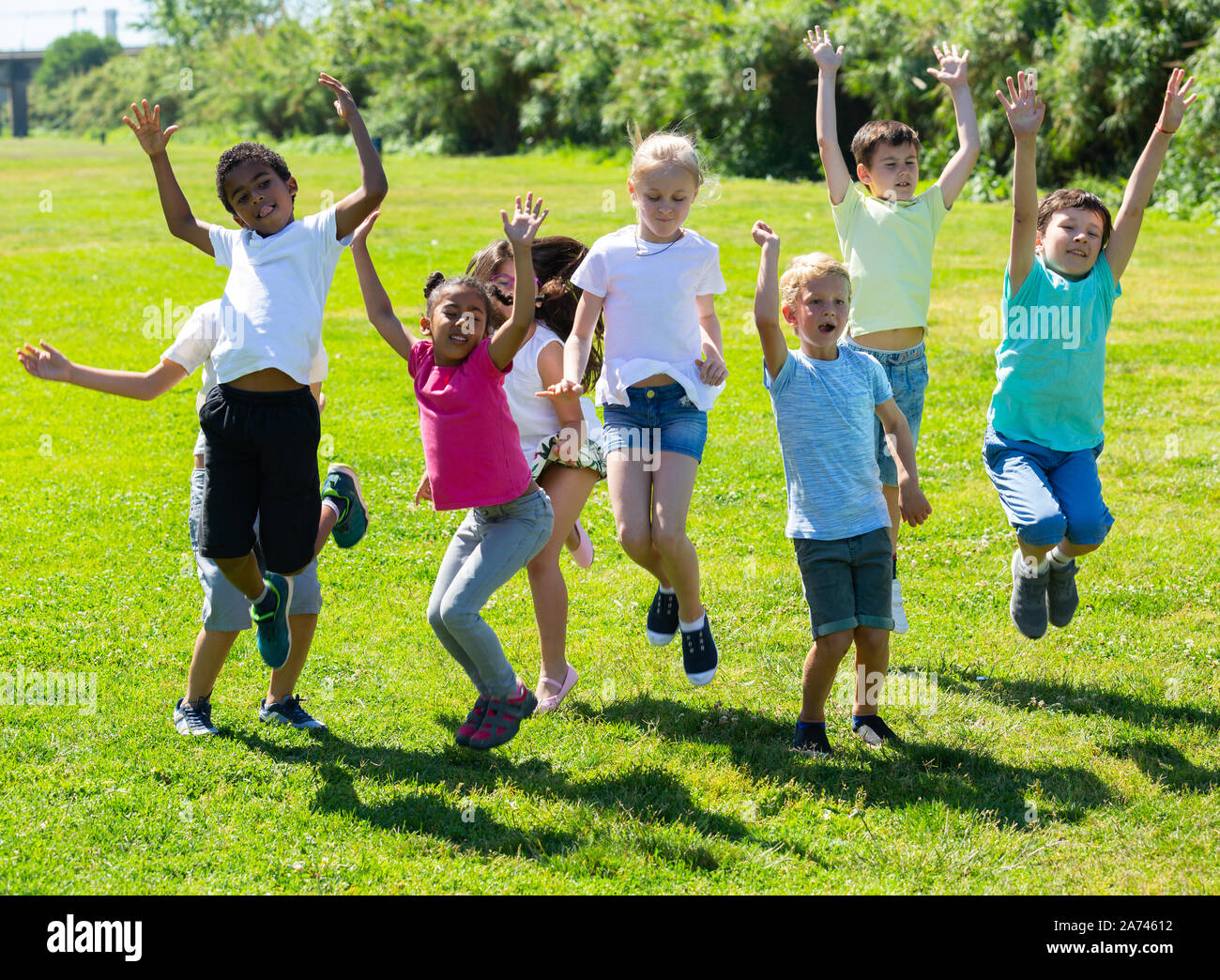 Group of happy children jumping and smiling together in park Stock ...