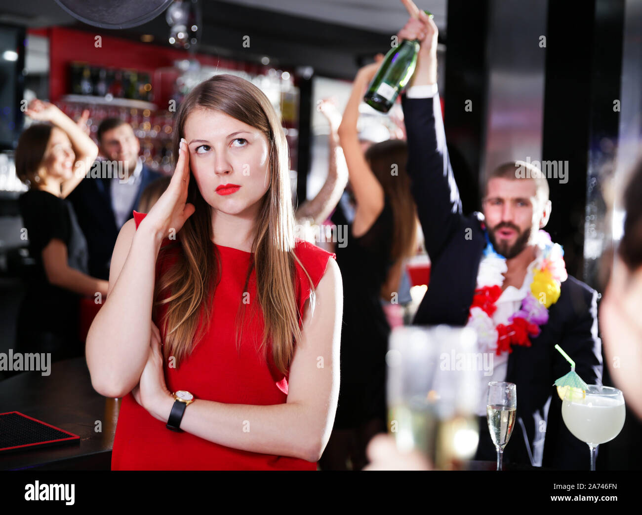 Offended young woman on background with drunk man on party at nightclub ...