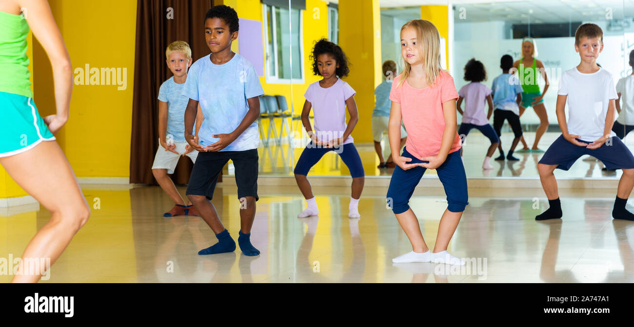 Group of children participating in dance class, following their teacher ...