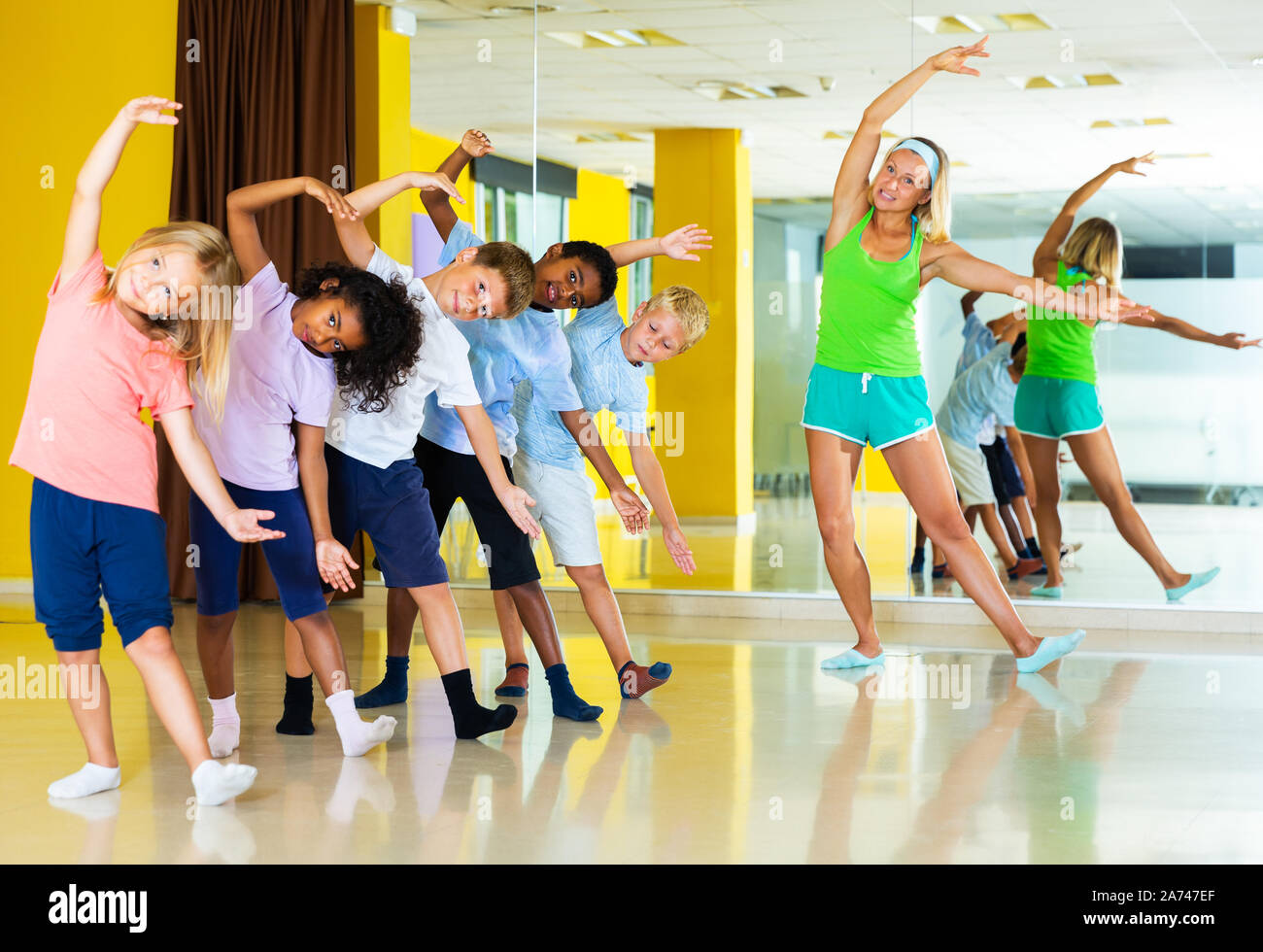 Group of tweens training movements of modern dance in choreography ...