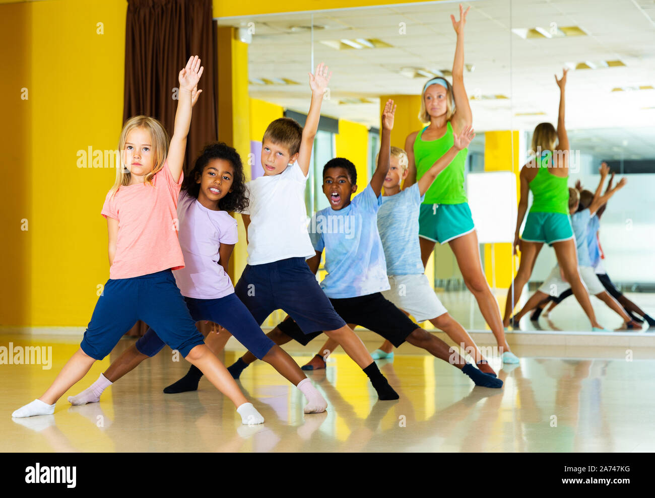 Happy children dancing synchronous group choreography with female coach ...