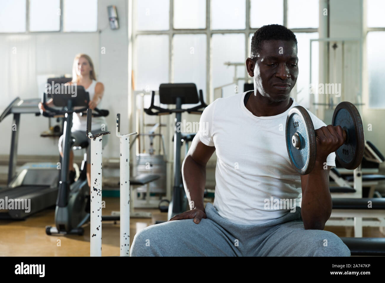 Portrait of African man doing exercises with dumbell at gym Stock Photo ...