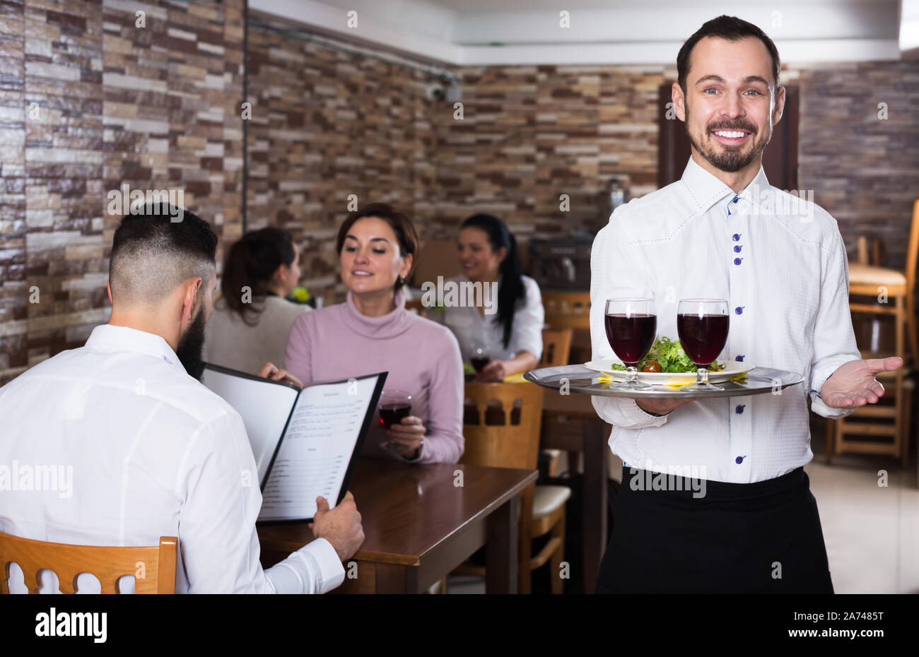 Young man waiter demonstrating hi-res stock photography and images - Alamy