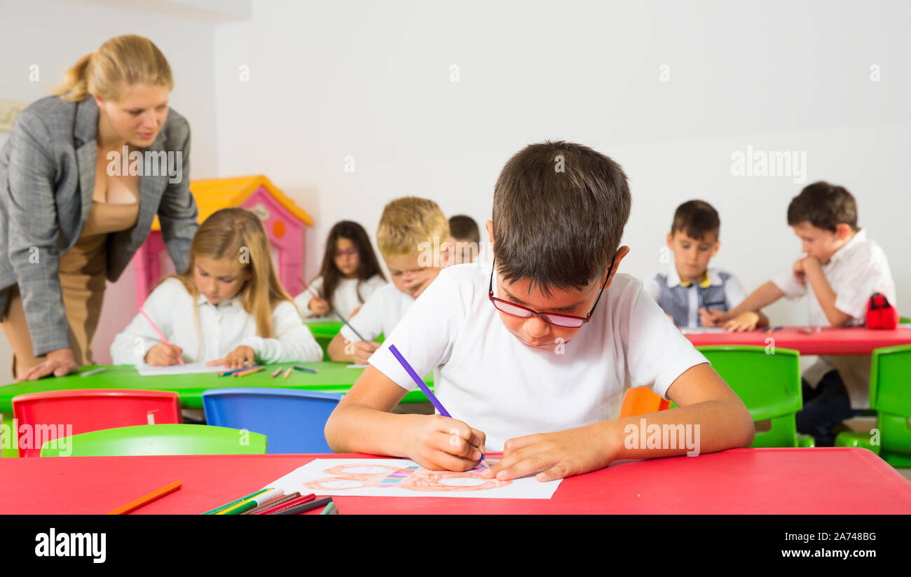 Little diligent schoolboy drawing at lesson in elementary school Stock ...