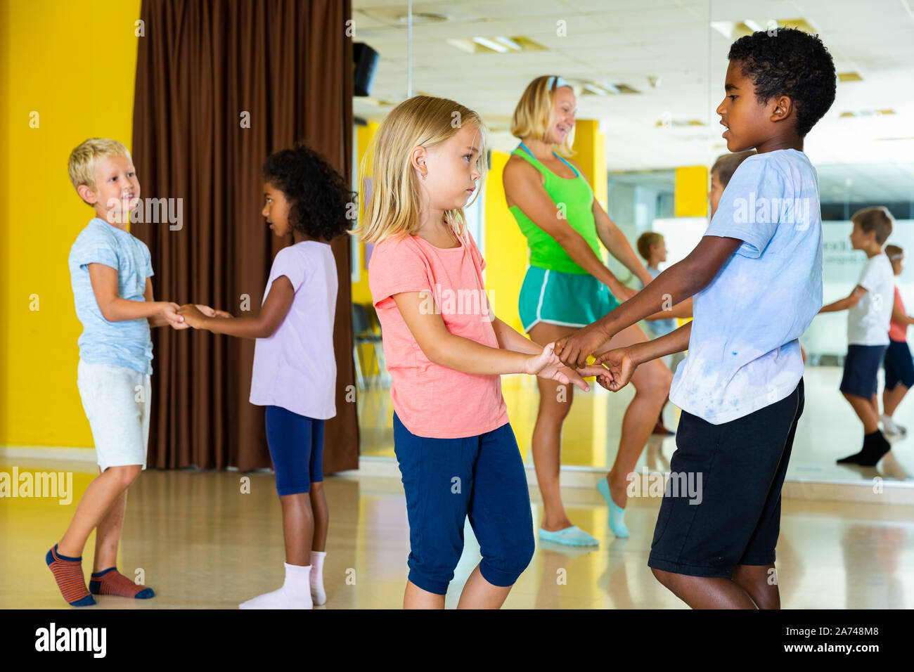 Positive little boys and girls dancing pair dance in the ballet studio ...