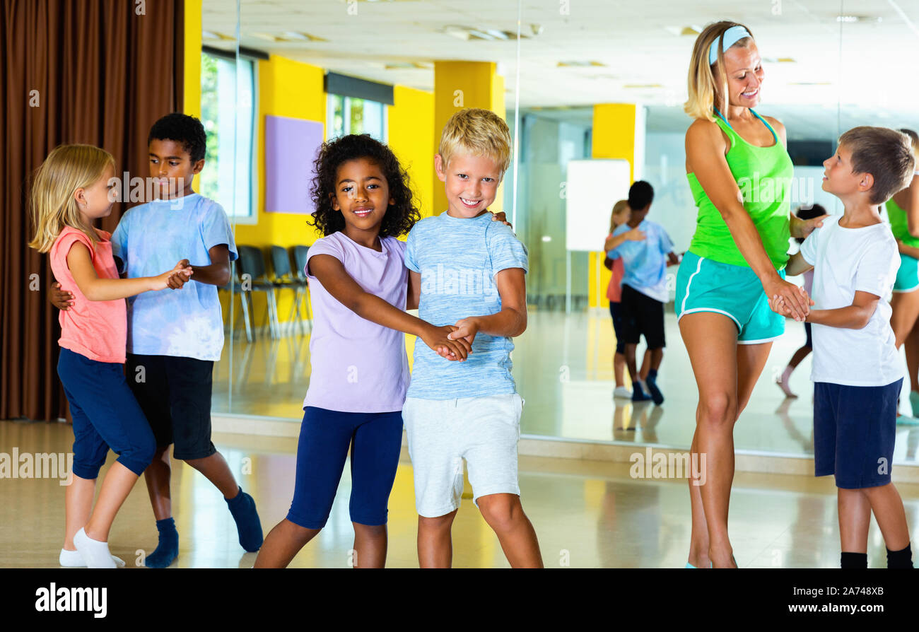 Diligent smiling positive children dancing together slow ballroom ...