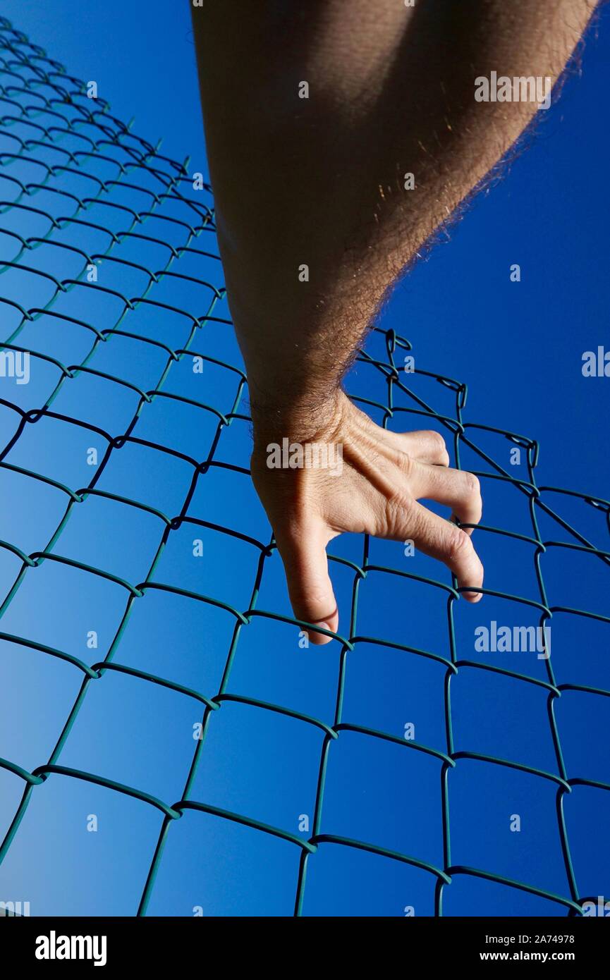 man hand grabbing a metallic fence on the street Stock Photo - Alamy