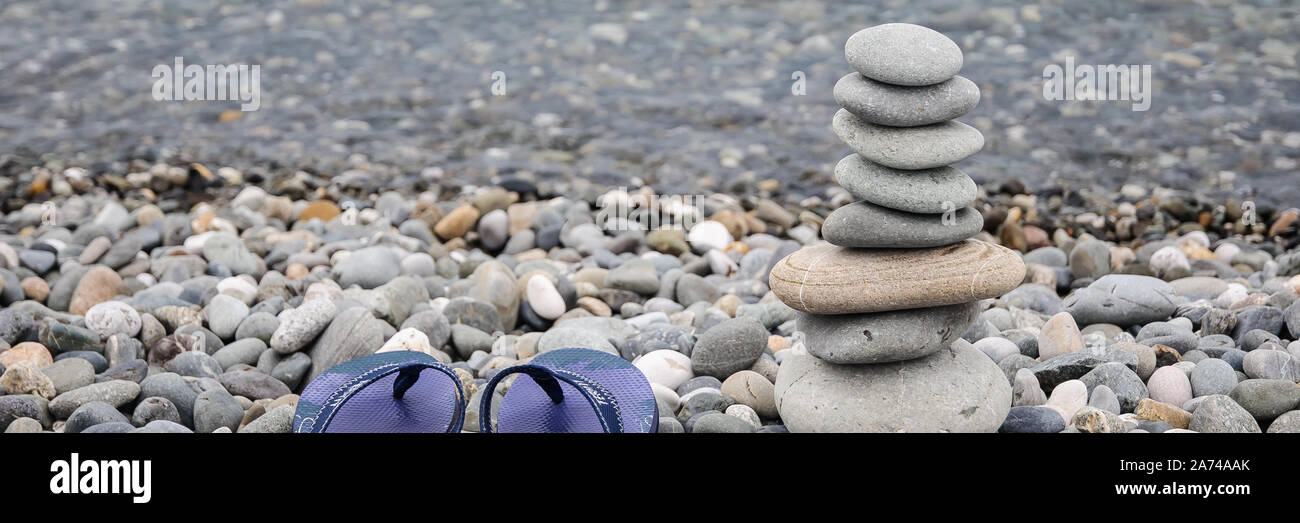 Pyramid of sea stones on pebbles of the sea shore. Seascape. The ...