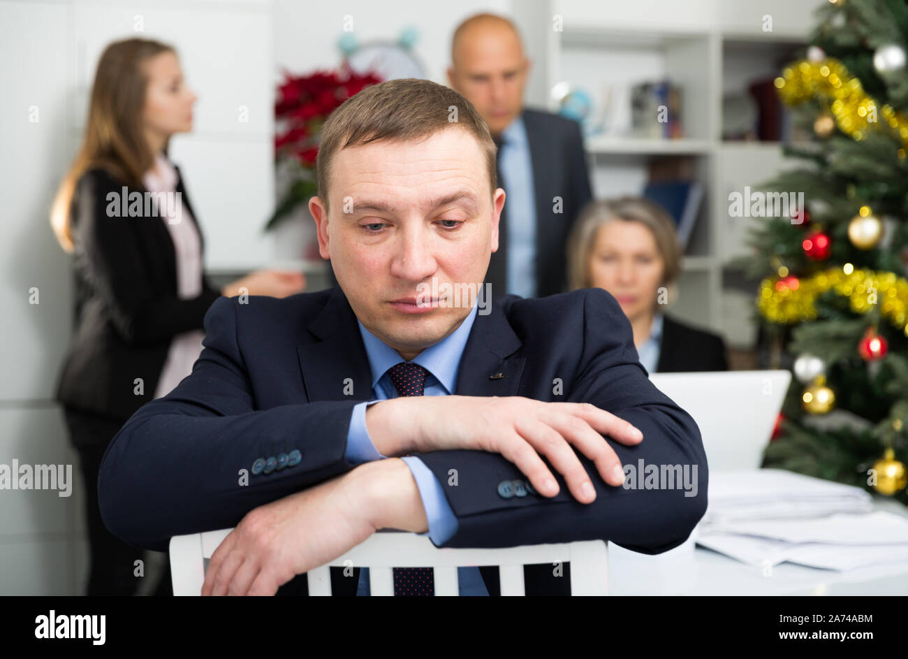 Business team tensely solving problems in office with offended man ... Business team tensely solving problems in office with offended man ...