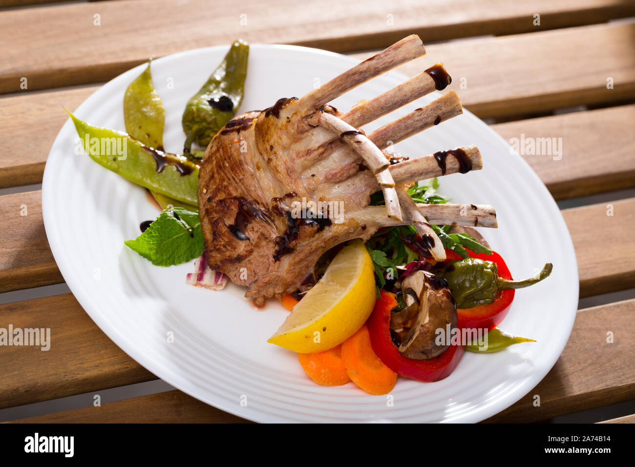 Rack of mutton chops surrounded by assorted fresh vegetables and mint ...