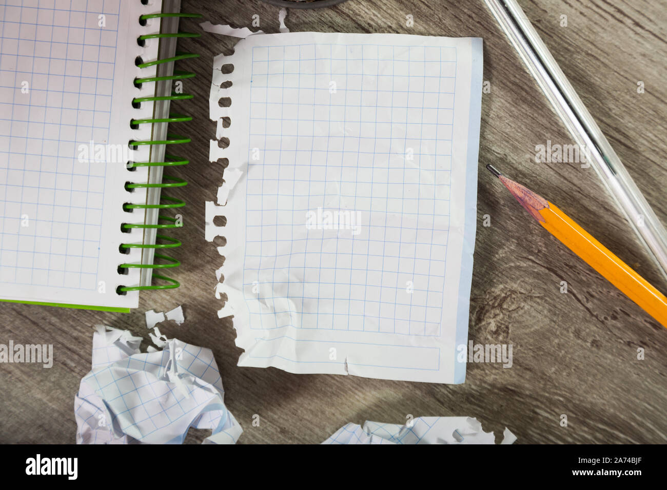 Torn crumpled notebook sheet in cage surrounded by stationery Stock ...