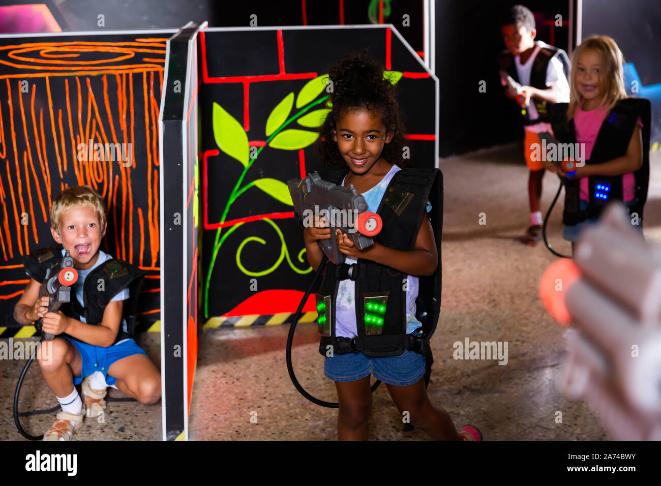 Teenager girl with laser pistol posing in laser tag labyrinth Stock ...
