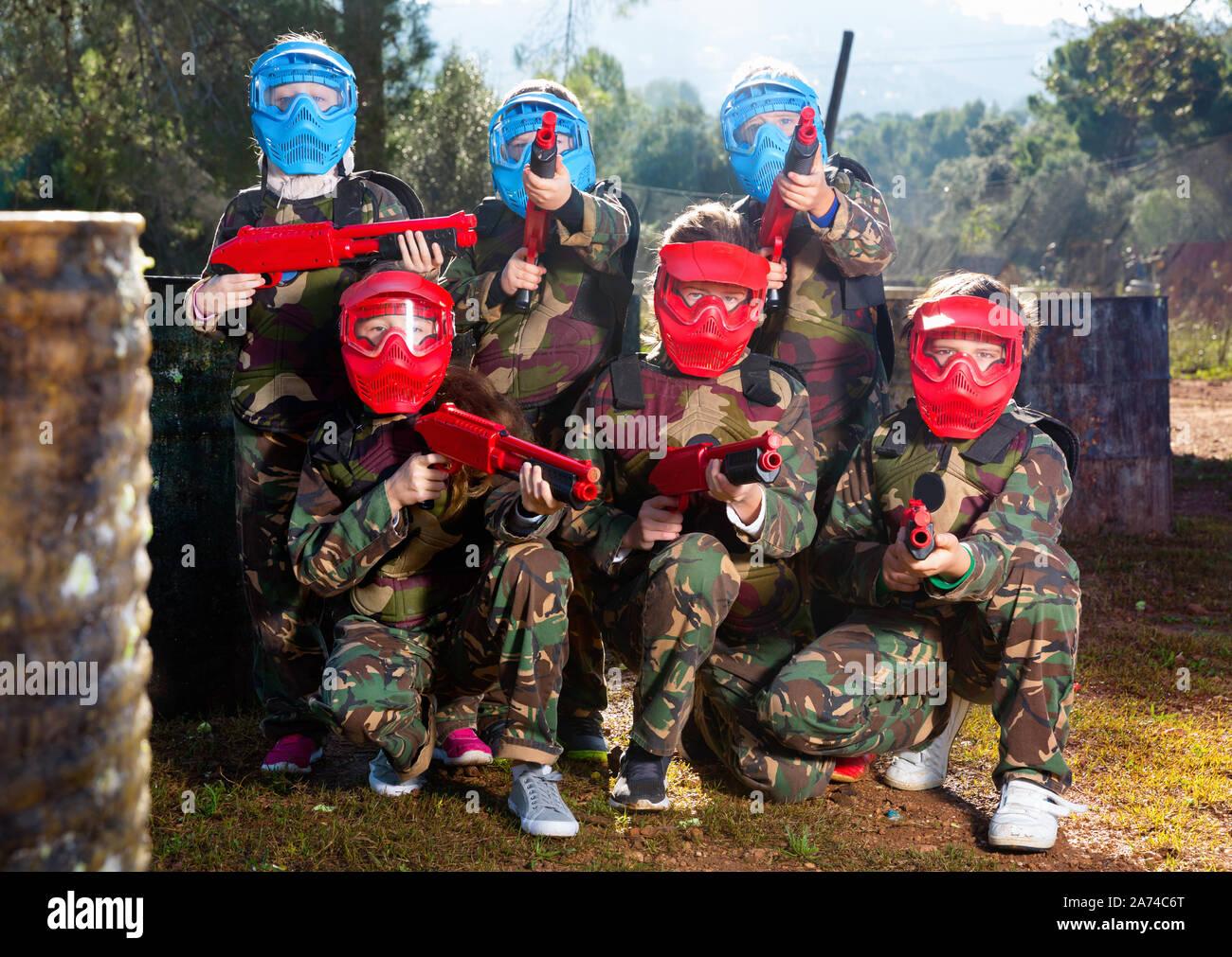 Friendly cheerful positive group of children paintball players in ...