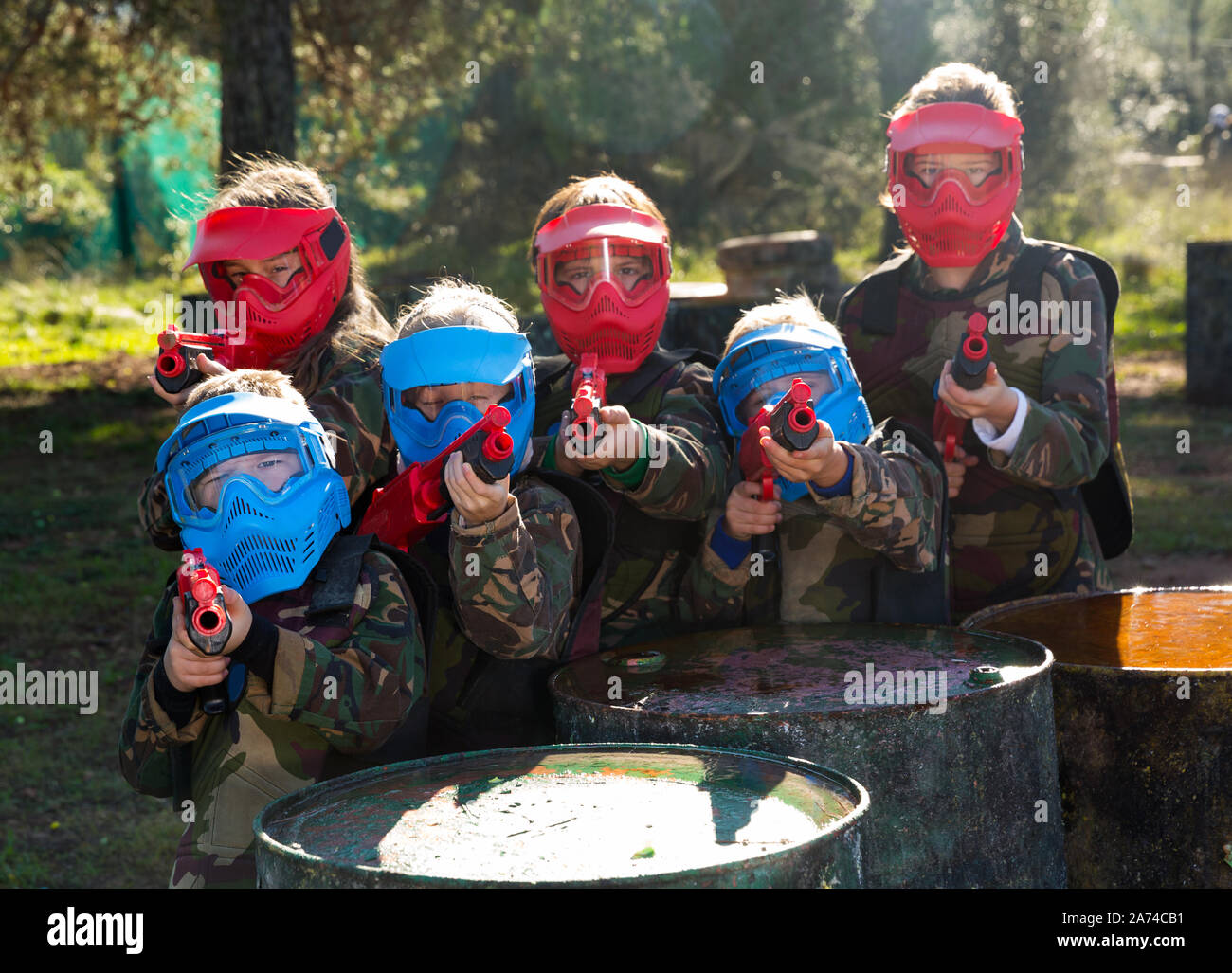 Portrait of sportive kids paintball players wearing uniform and holding ...