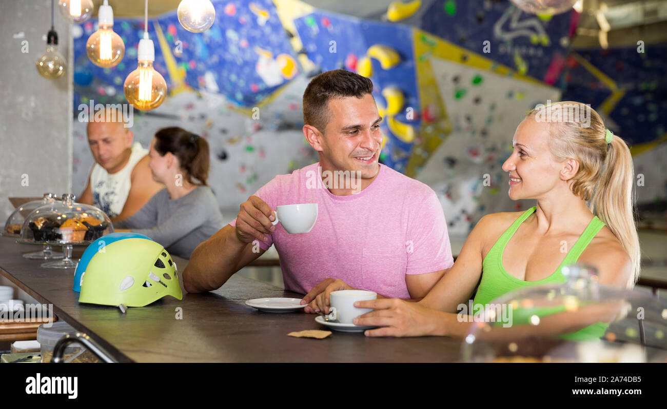 Couple of sporty people relaxing during workout at bouldering gym ...