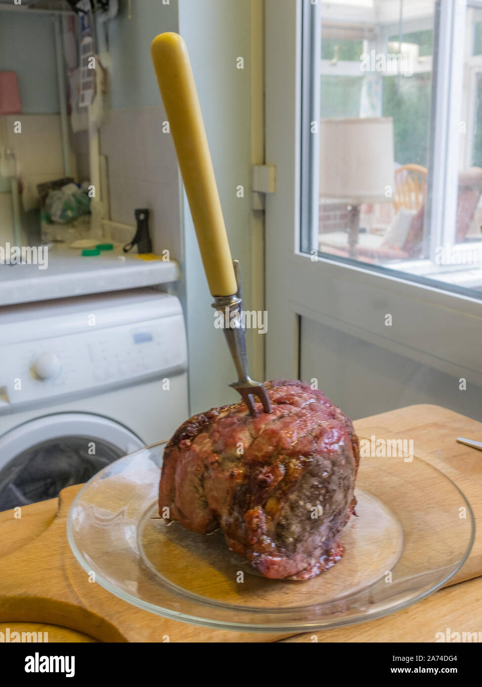 Steaming hot roasted joint of beef ready for carving before a Sunday ...