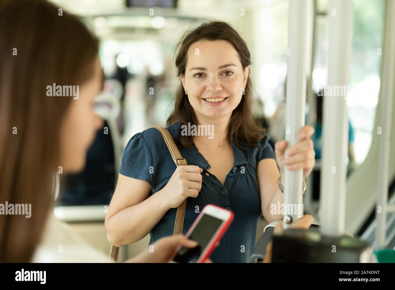 Portrait of cheerful woman passenger standing in public bus Stock Photo ...