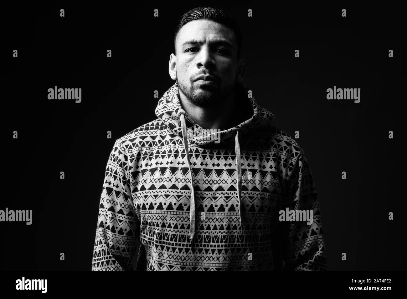 Young muscular Hispanic man against black background Stock Photo - Alamy