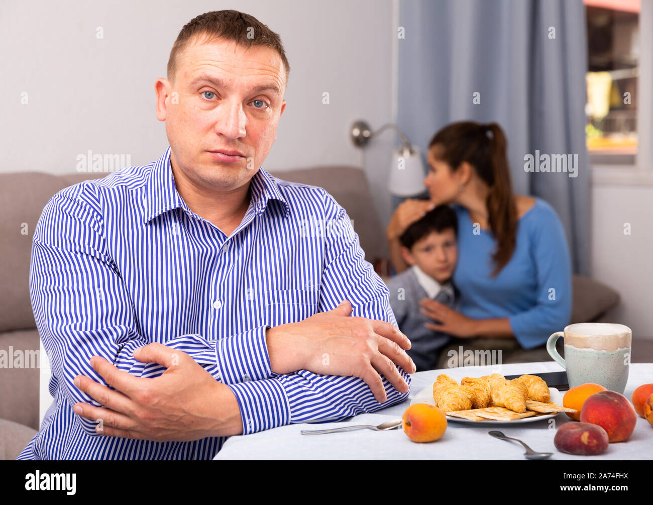 Sad father and mom with son having quarrel in home. Focus on father ...