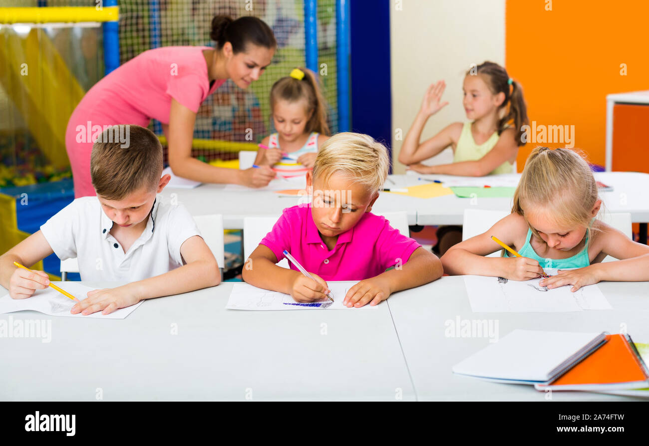 smiling children sitting together and studying in class at school Stock ...