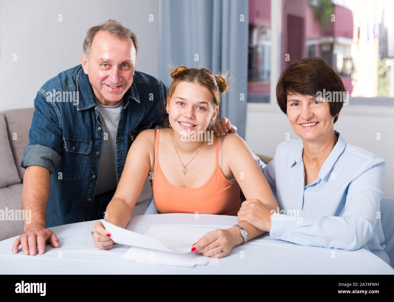 Female is singing contract with her parents indoor Stock Photo - Alamy
