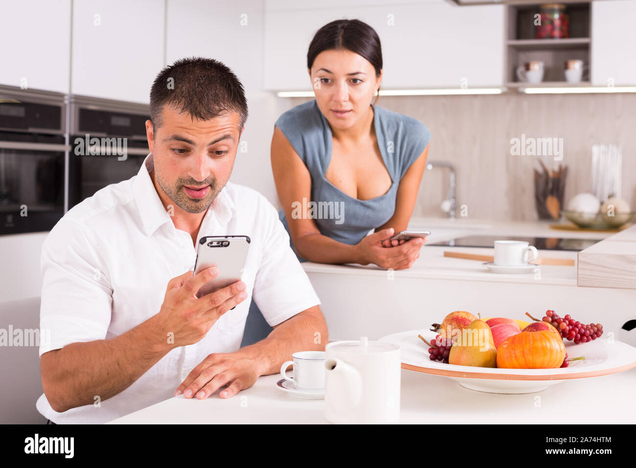Husband and wife in kitchen texting hi-res stock photography and images ...